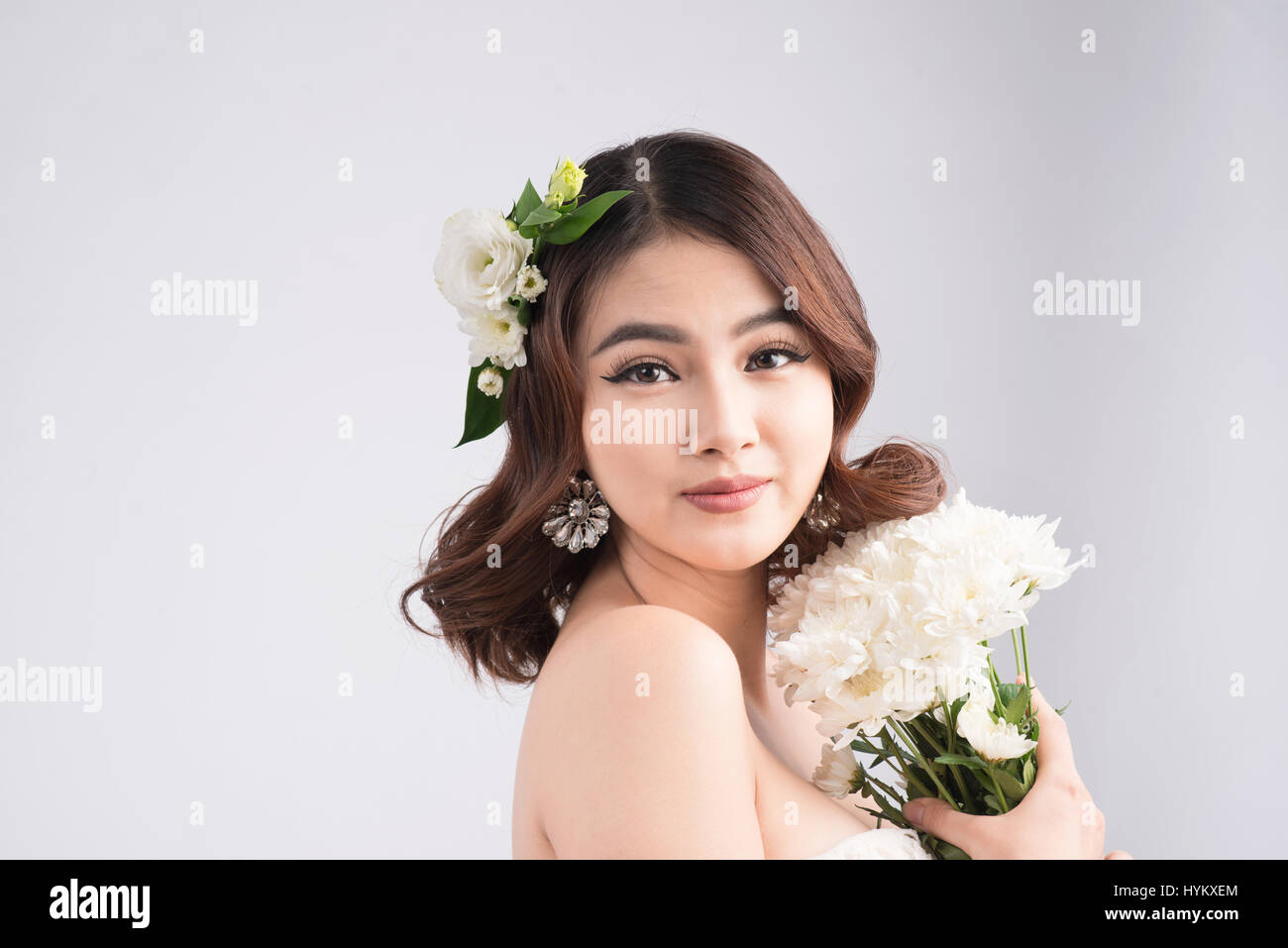 Beautiful asian woman bride on grey background. Closeup portraits with a professional makeup ...