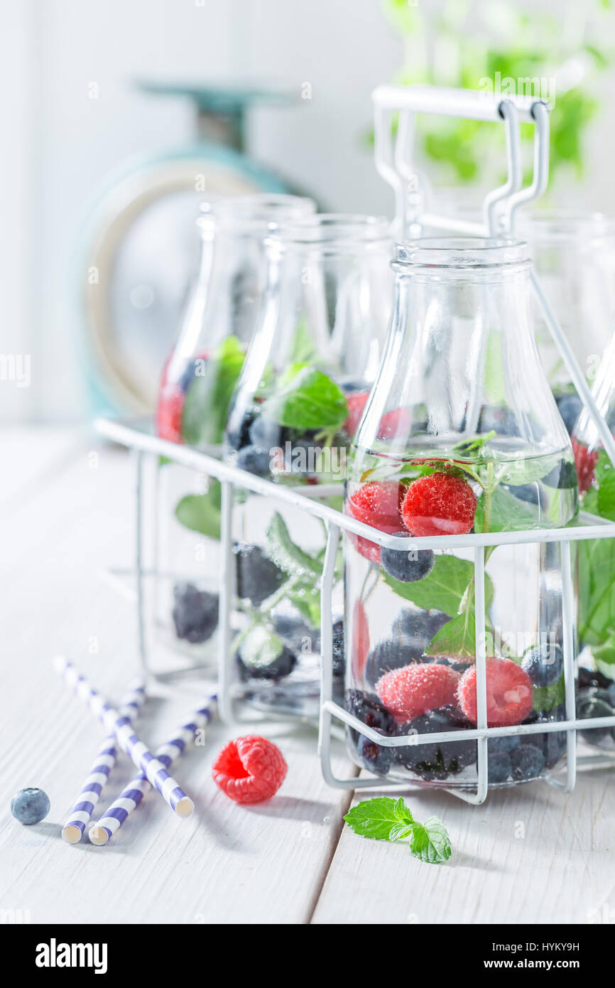 Sparkling soda in bottle with raspberries, blueberries and blackberries ...
