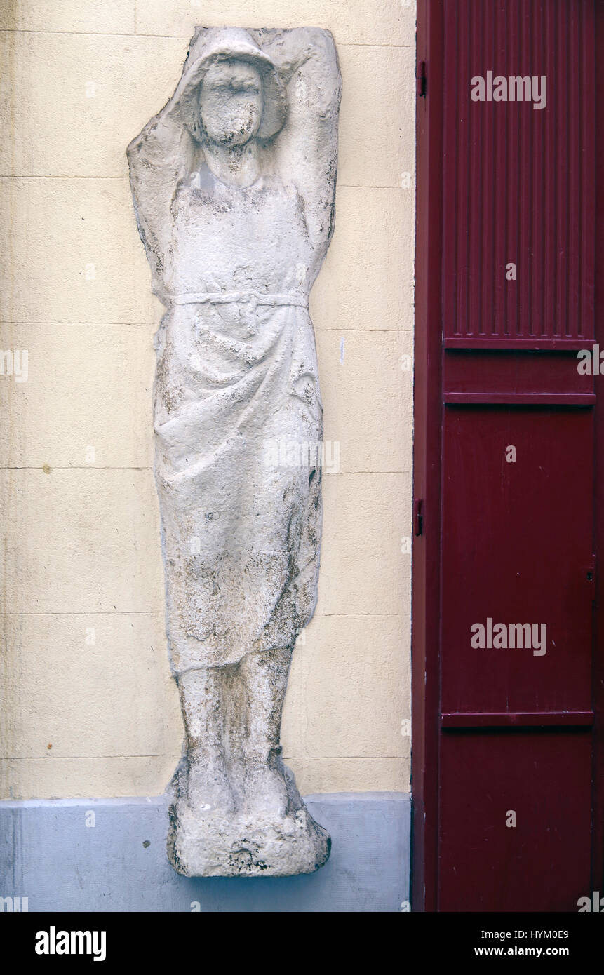 A presumably very old carved figure of a woman embedded in a wall in a ...