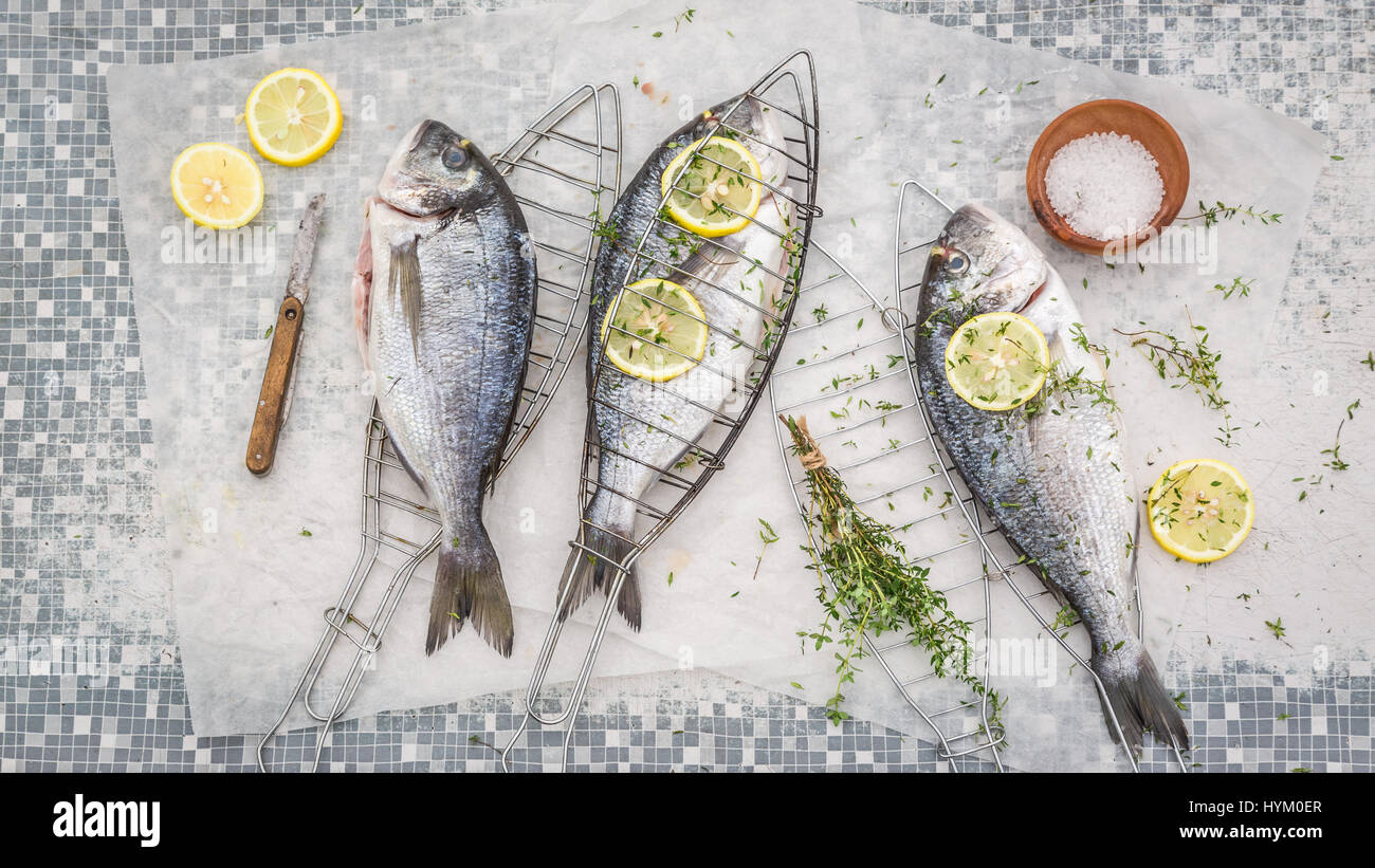 Freshly caught whole sea bream with thyme and salt Stock Photo - Alamy