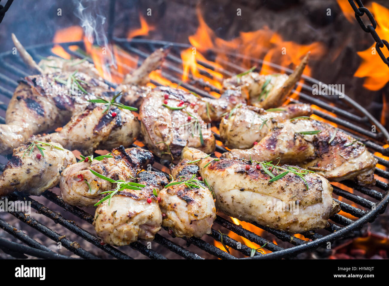 Hot chicken on grill with spices and rosemary Stock Photo - Alamy