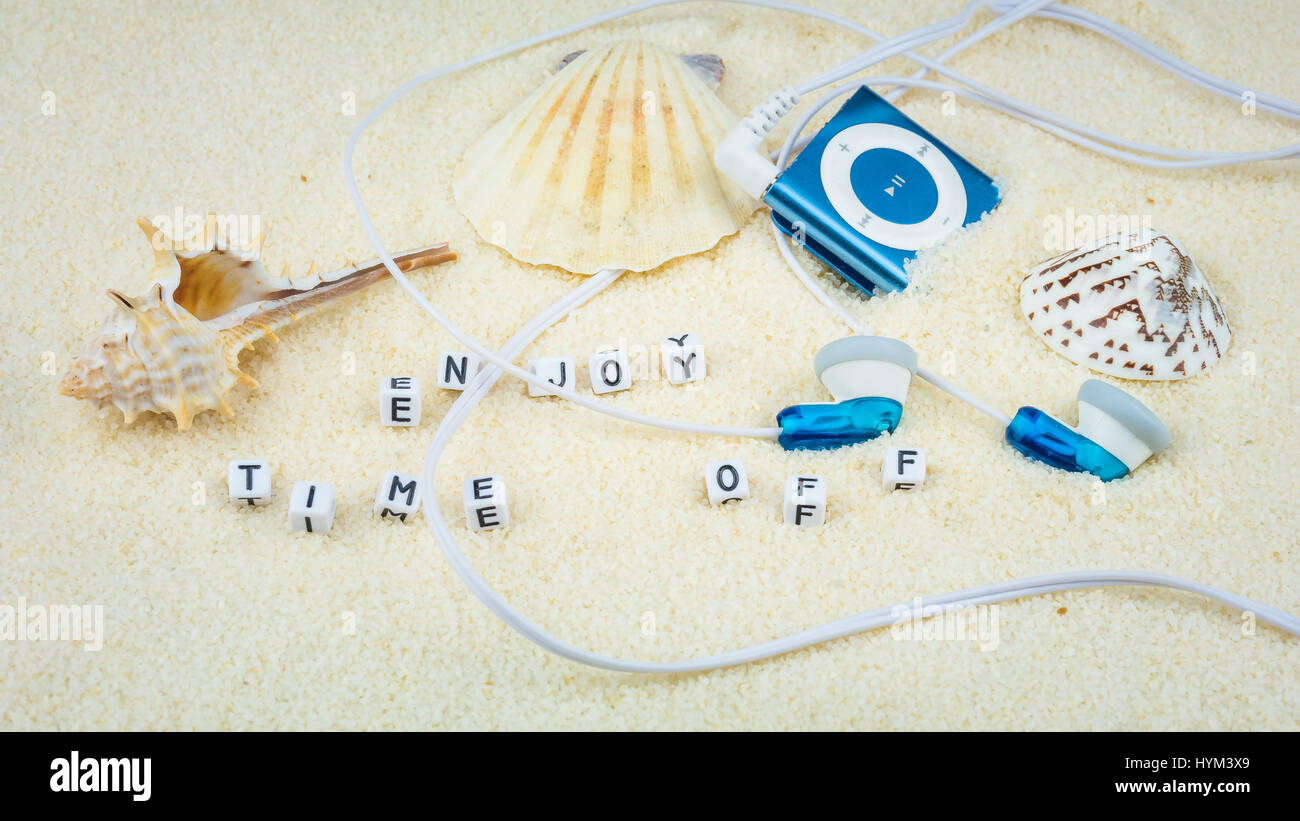 Enjoy time off letters between sea shells and audio player on sandy ...
