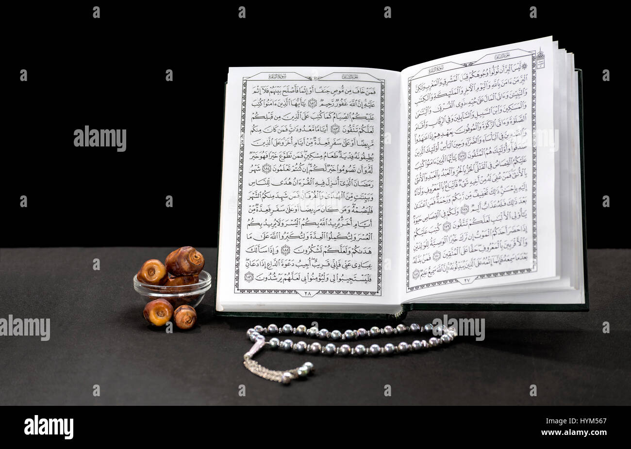 Open Book of Quran With Rosary and Dates Over Black Background Stock ...