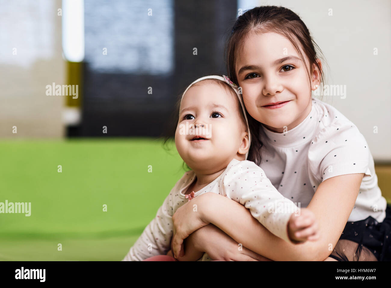 Elder sister hugging with her little baby sister Stock Photo - Alamy