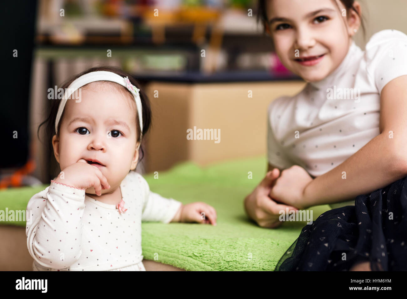 Curious little baby girl and her elder sister Stock Photo - Alamy