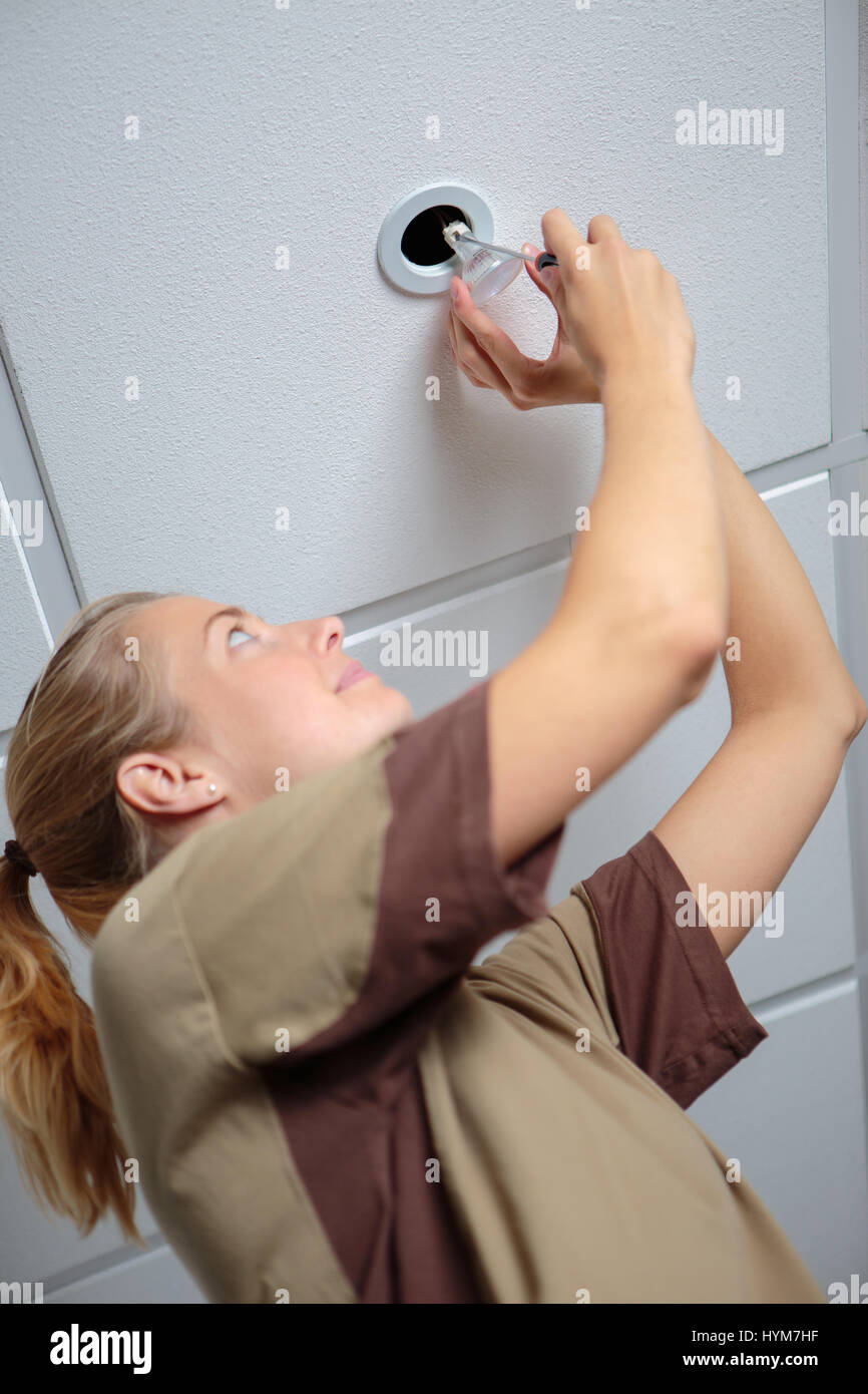 Lady changing bulb in spotlight Stock Photo - Alamy