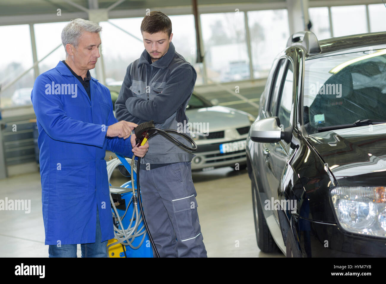 teenager in professional training with garage owner Stock Photo - Alamy