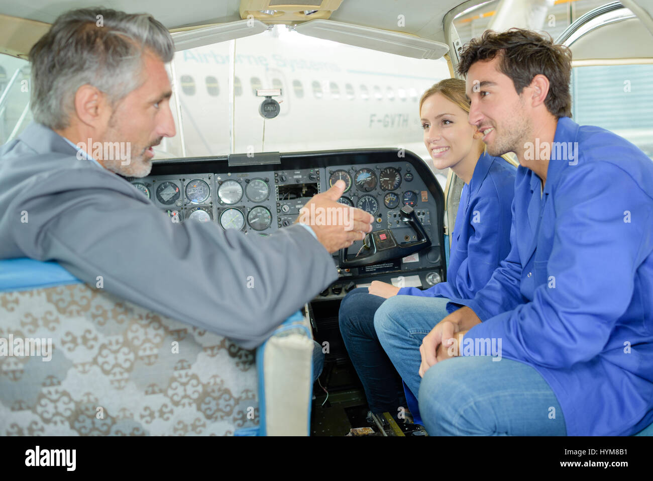 Teacher talking to students in aircraft cockpit Stock Photo - Alamy