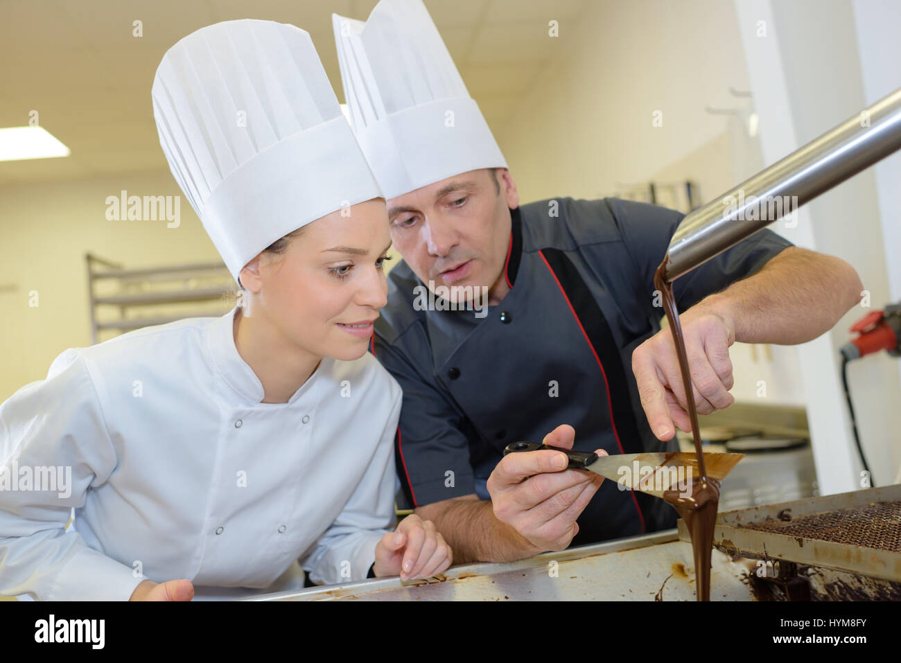chefs in hotel or restaurant kitchen making chocolate dessert Stock ...