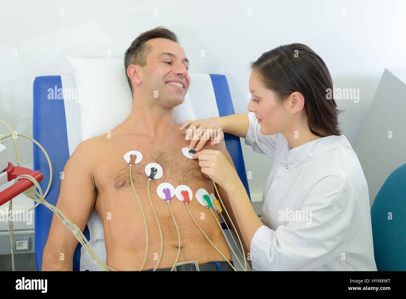 Nurse attaching heart monitor pads to patient Stock Photo - Alamy
