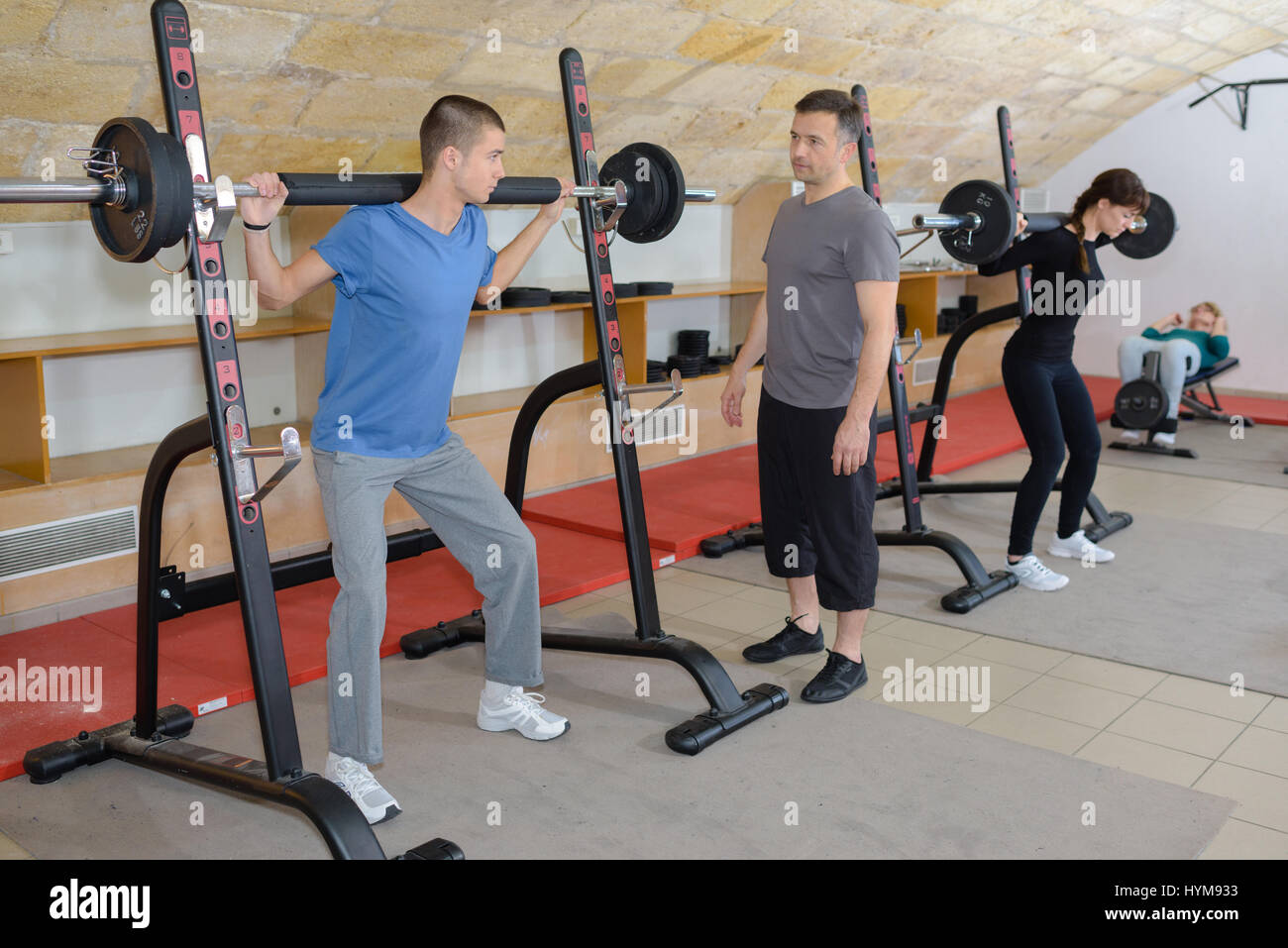 teen training with weights at gym club with coach Stock Photo - Alamy