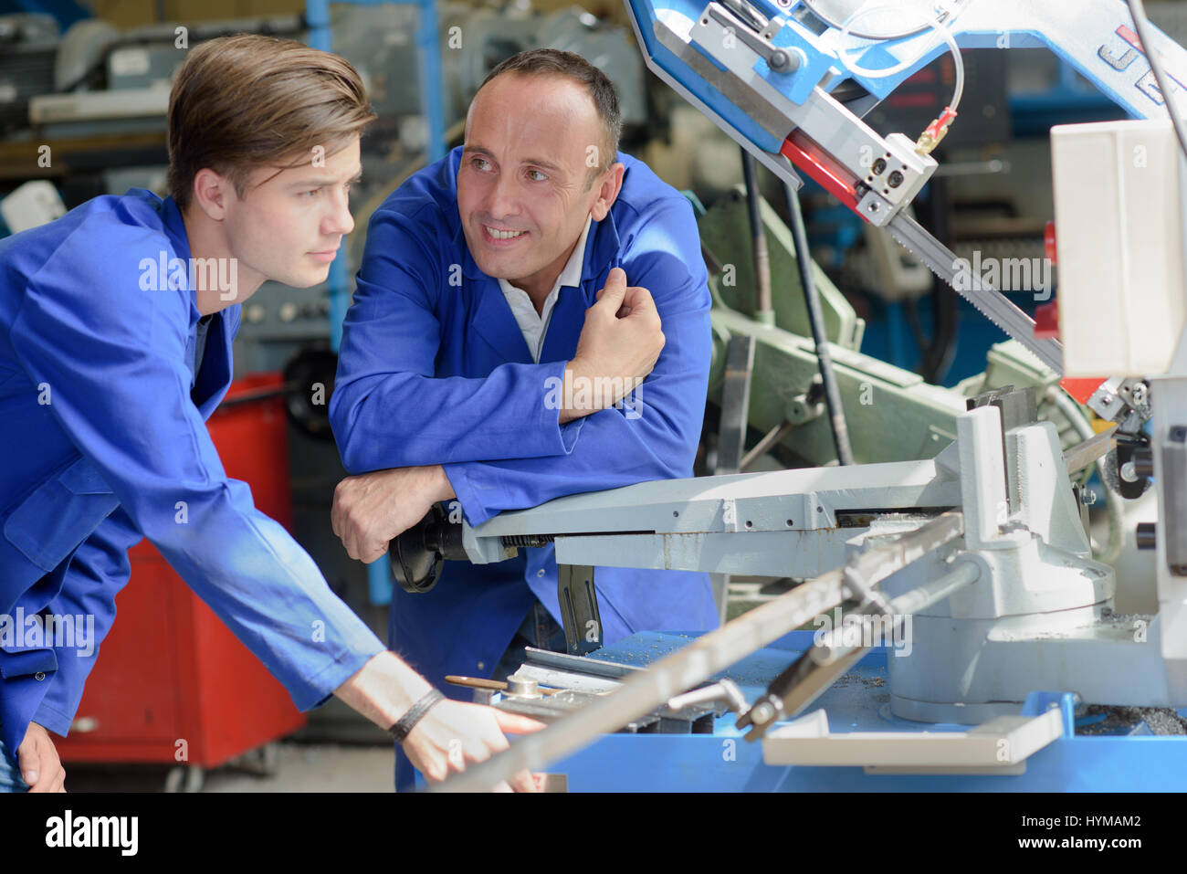 Junior and senior engineers looking at equipment Stock Photo - Alamy
