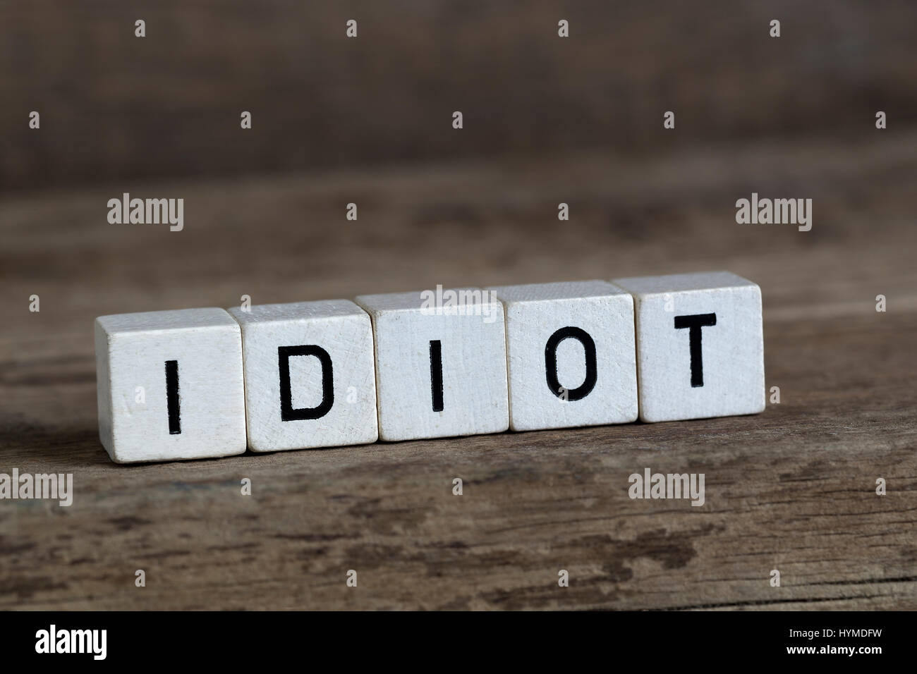 Idiot, written in cubes on a wooden background Stock Photo - Alamy