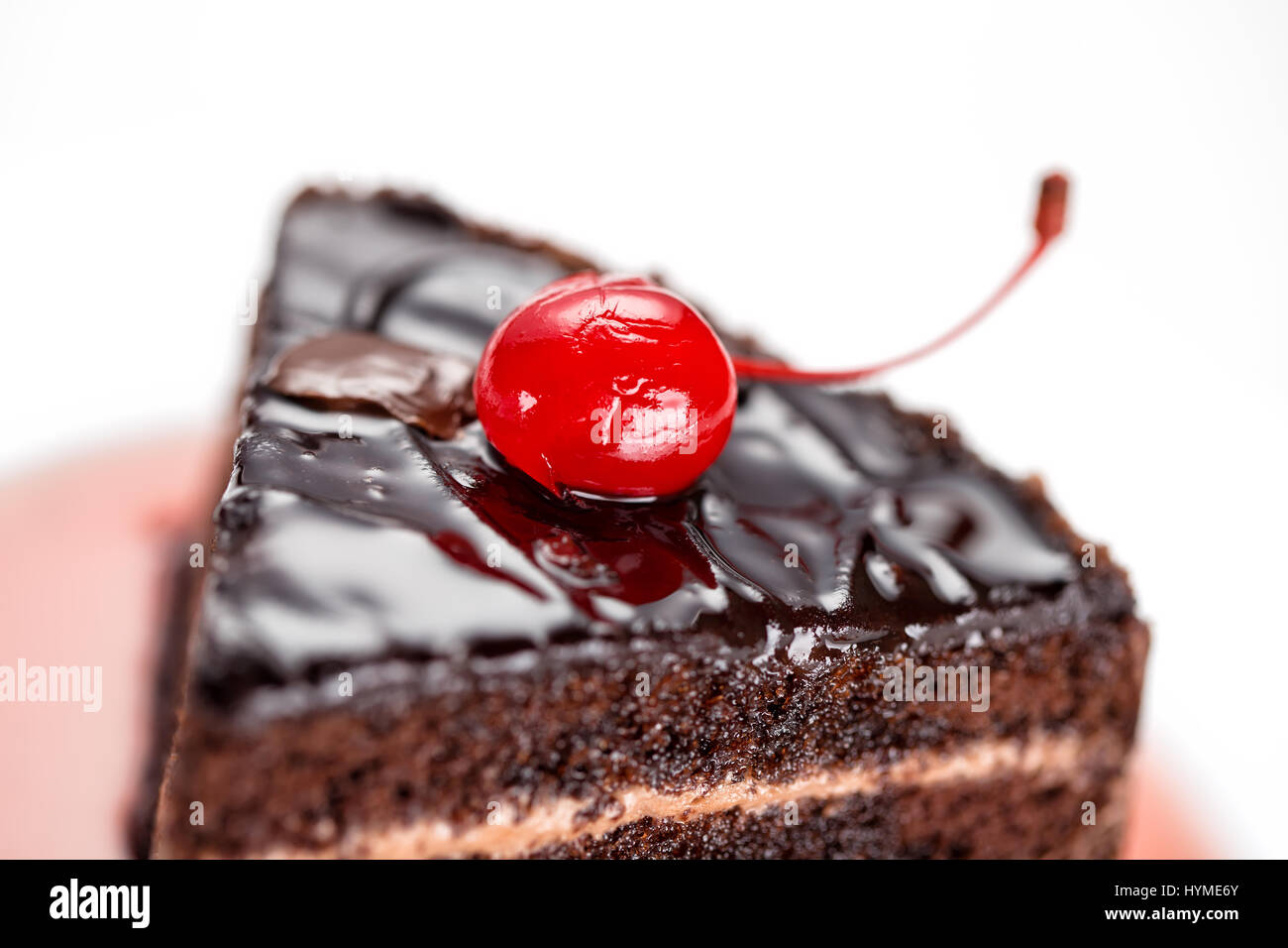 Fragment of a chocolate cake with a cherry isolated on white background ...