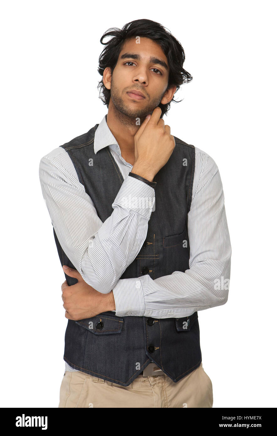 Portrait of a serious young man with hand to face standing on isolated ...