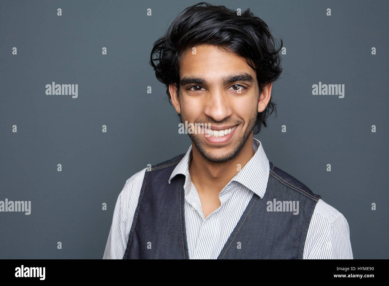 Horizontal portrait of a happy young man smiling against fray ...