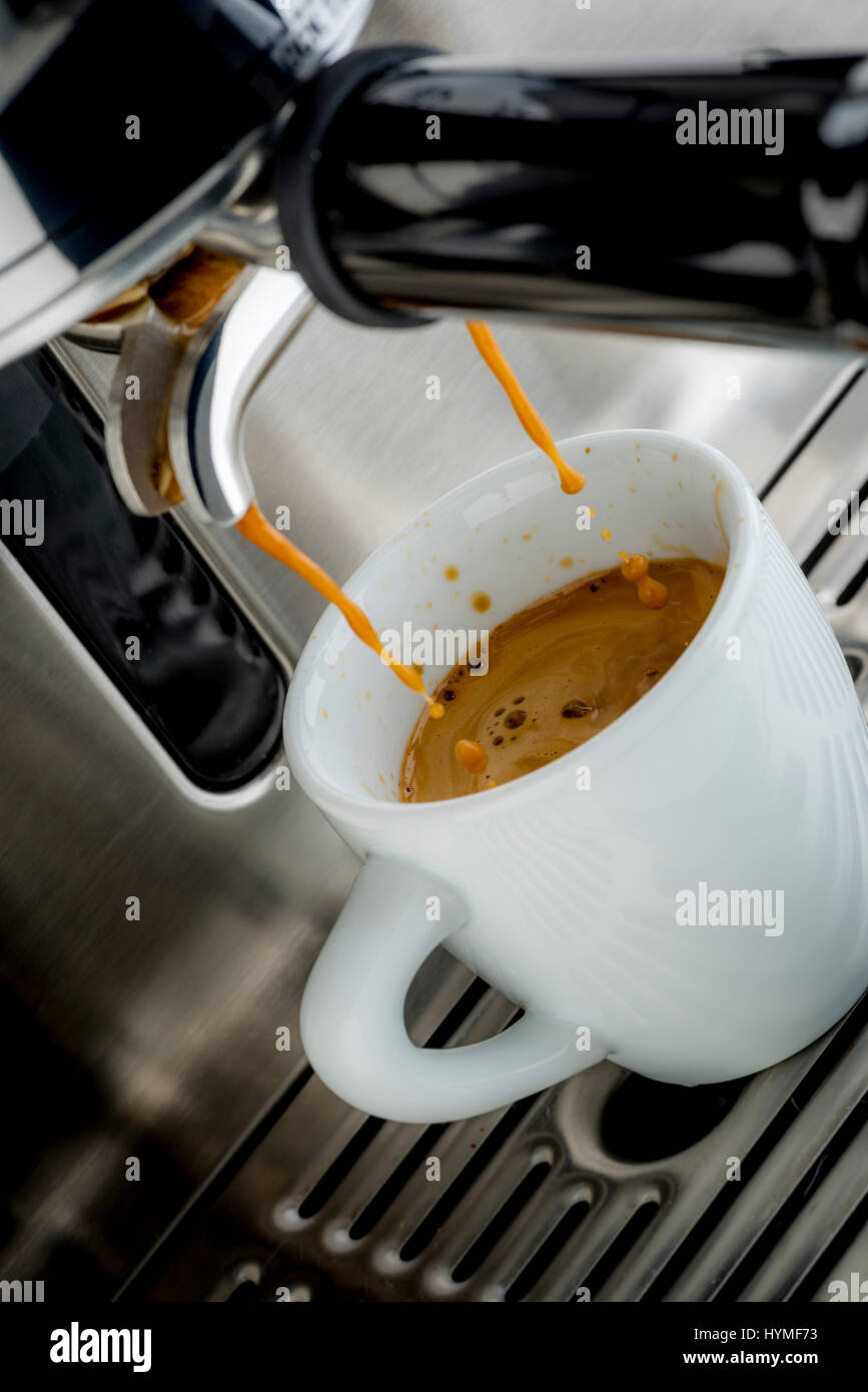 Traditional pump espresso coffee machine pouring shot into white cup ...