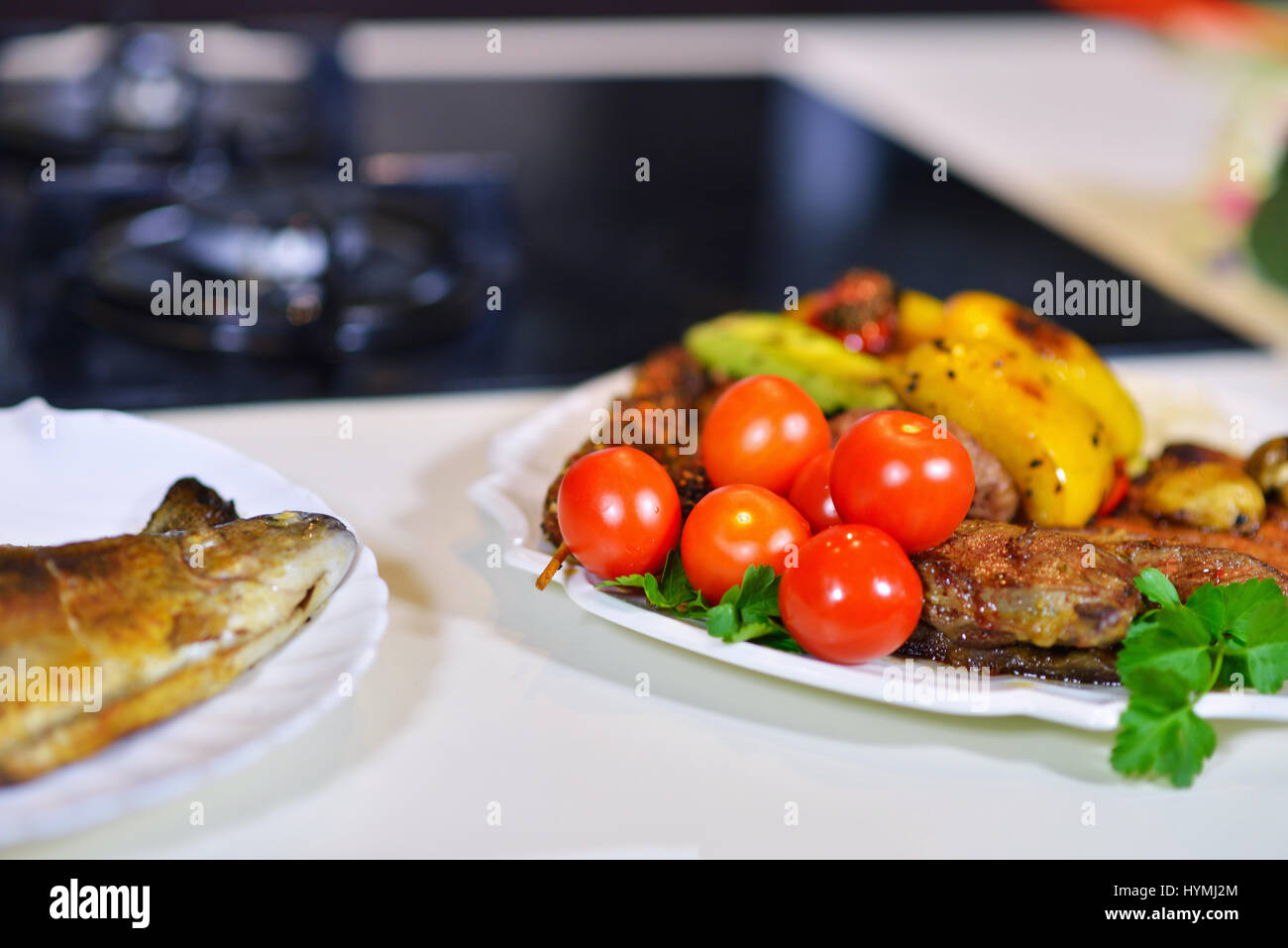 Tasty baked fish on plate on table close-up Stock Photo - Alamy
