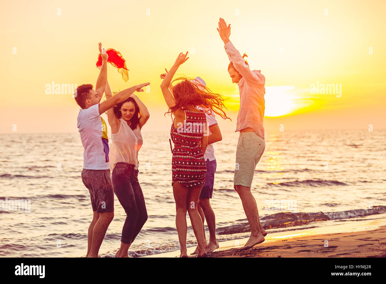 Young People Dancing On Beach at Sunset Stock Photo - Alamy