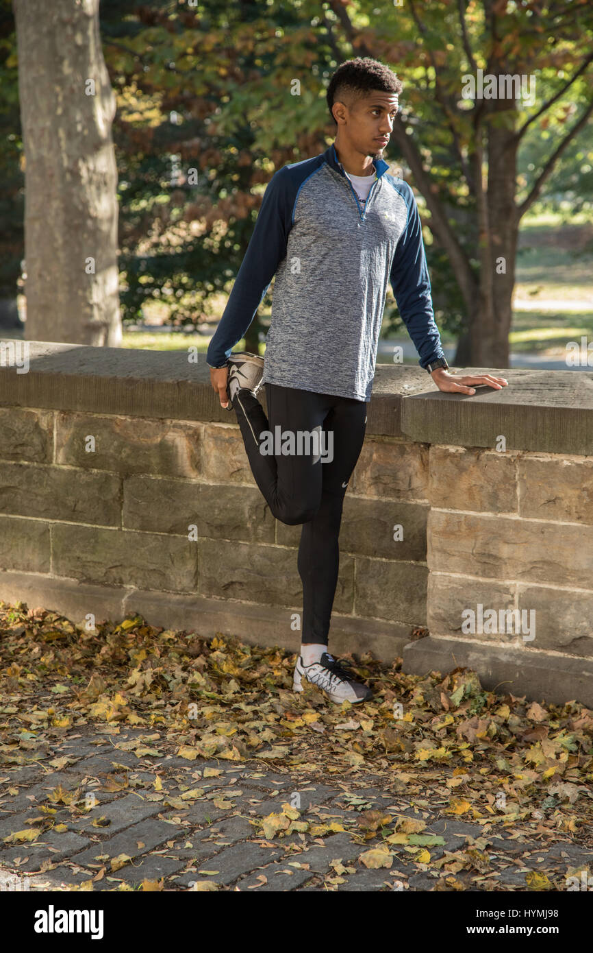 A young black man stretches to prepare for a run. Shot in Brooklyn, New ...