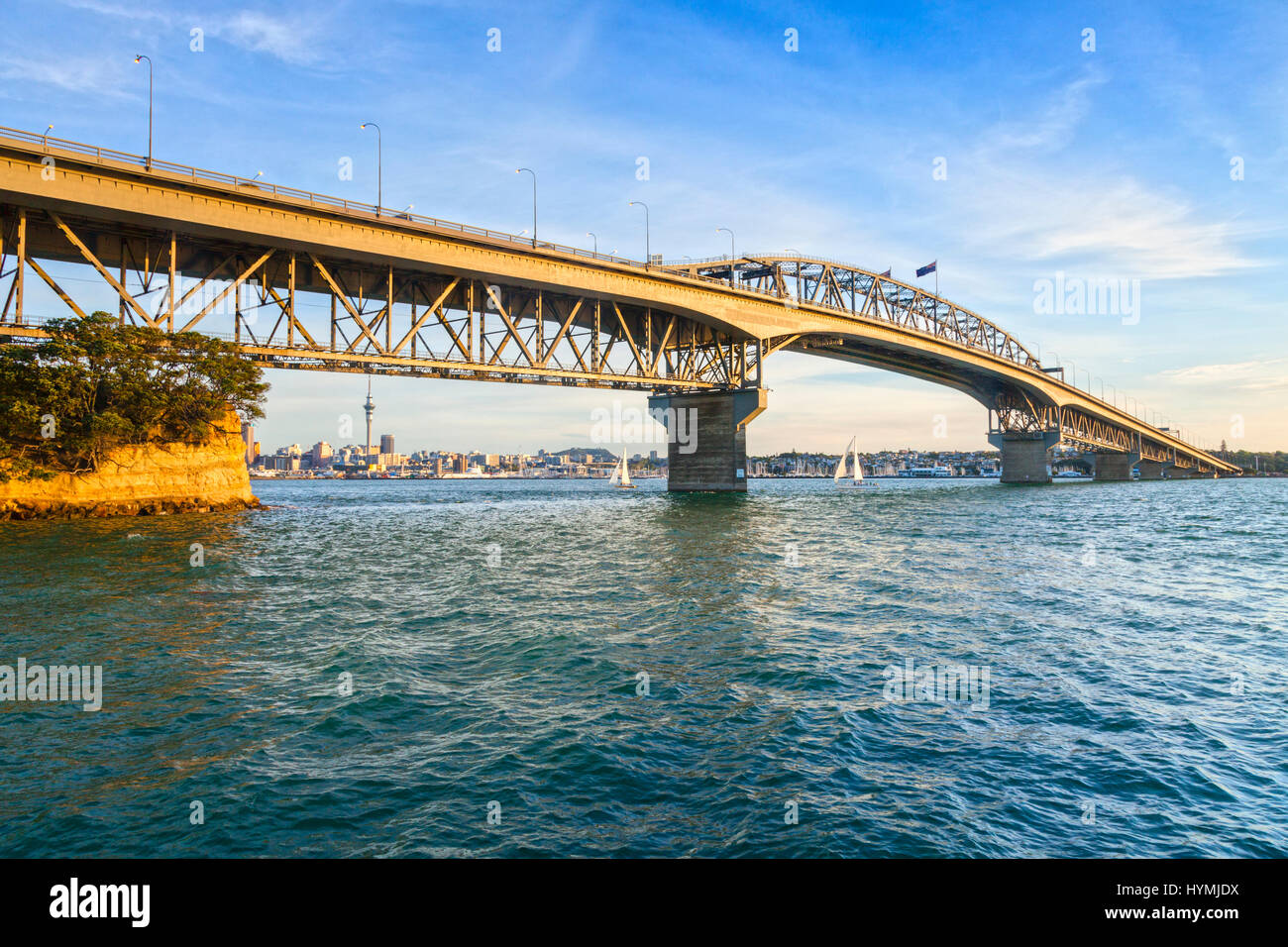 Auckland Harbour Bridge in evening light with yachts passing under ...