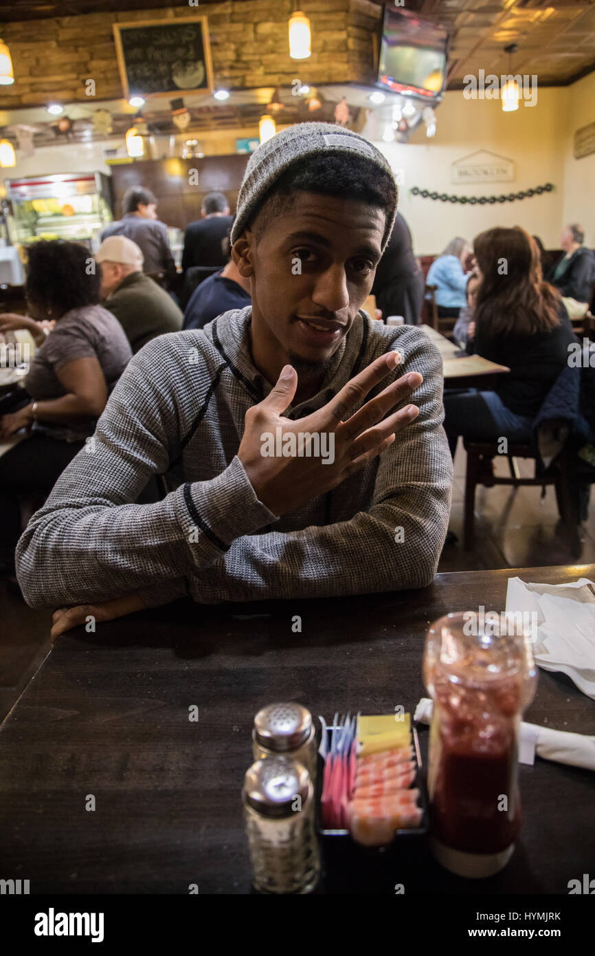 A young man poses while he waits for his food in a New York City diner ...