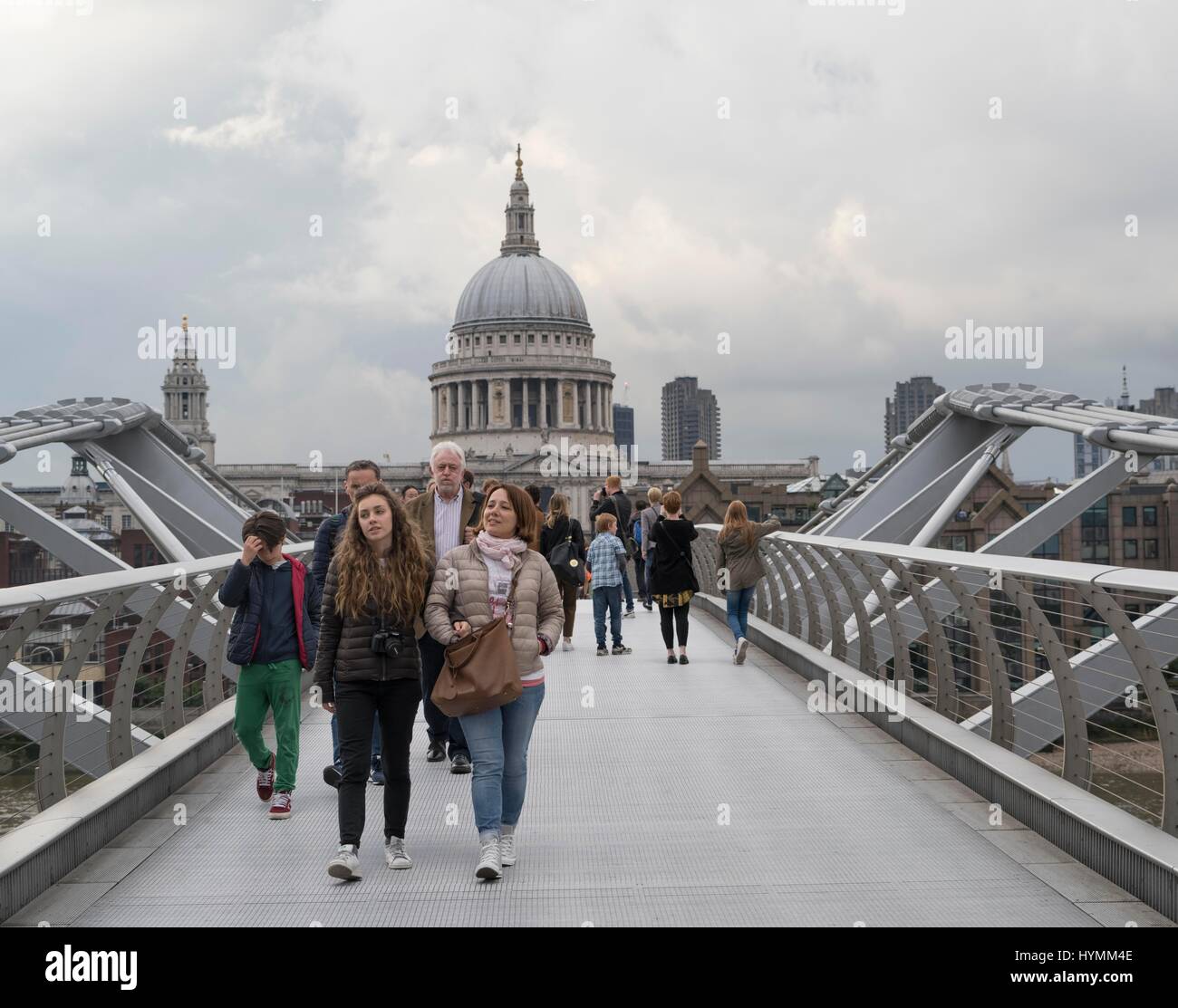 Pedestrians crossing the London Millennium Footbridge in London with St ...