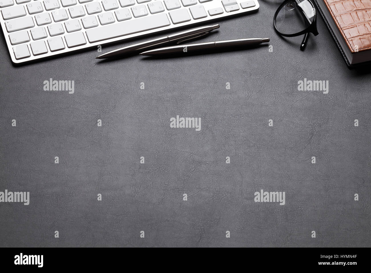 Office leather desk table with pc, notepad, glasses, pencil and pen ...