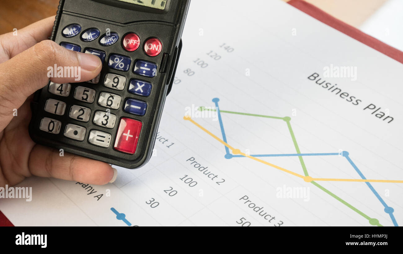 Typing the calculator with business plan paper Stock Photo - Alamy