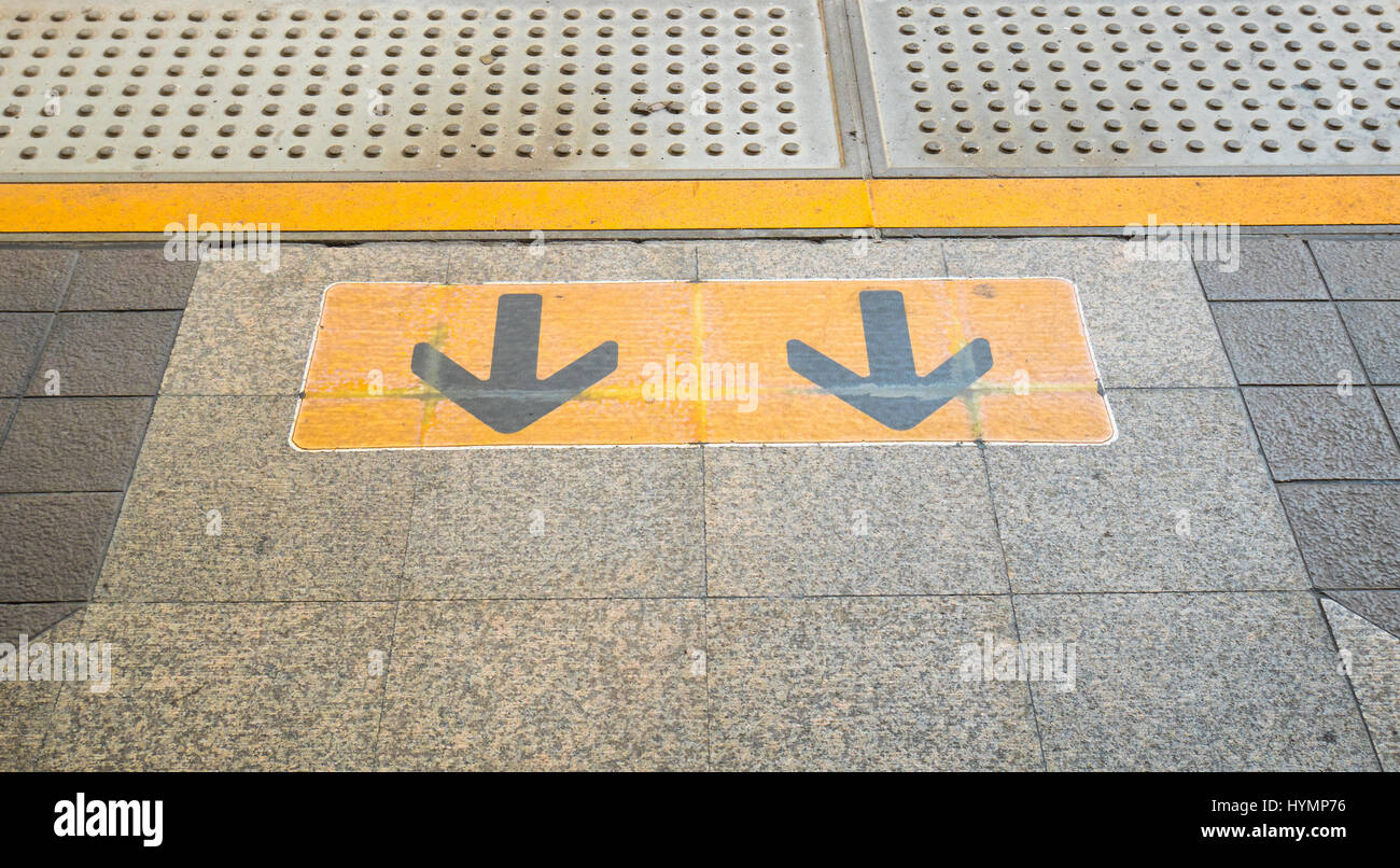 Arrow sign on Railway platform at train station Stock Photo - Alamy