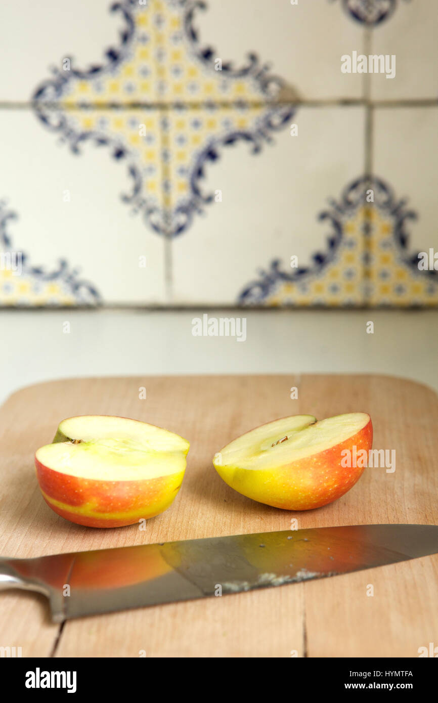 Close up apple sliced in half with kitchen knife indoors Stock Photo ...
