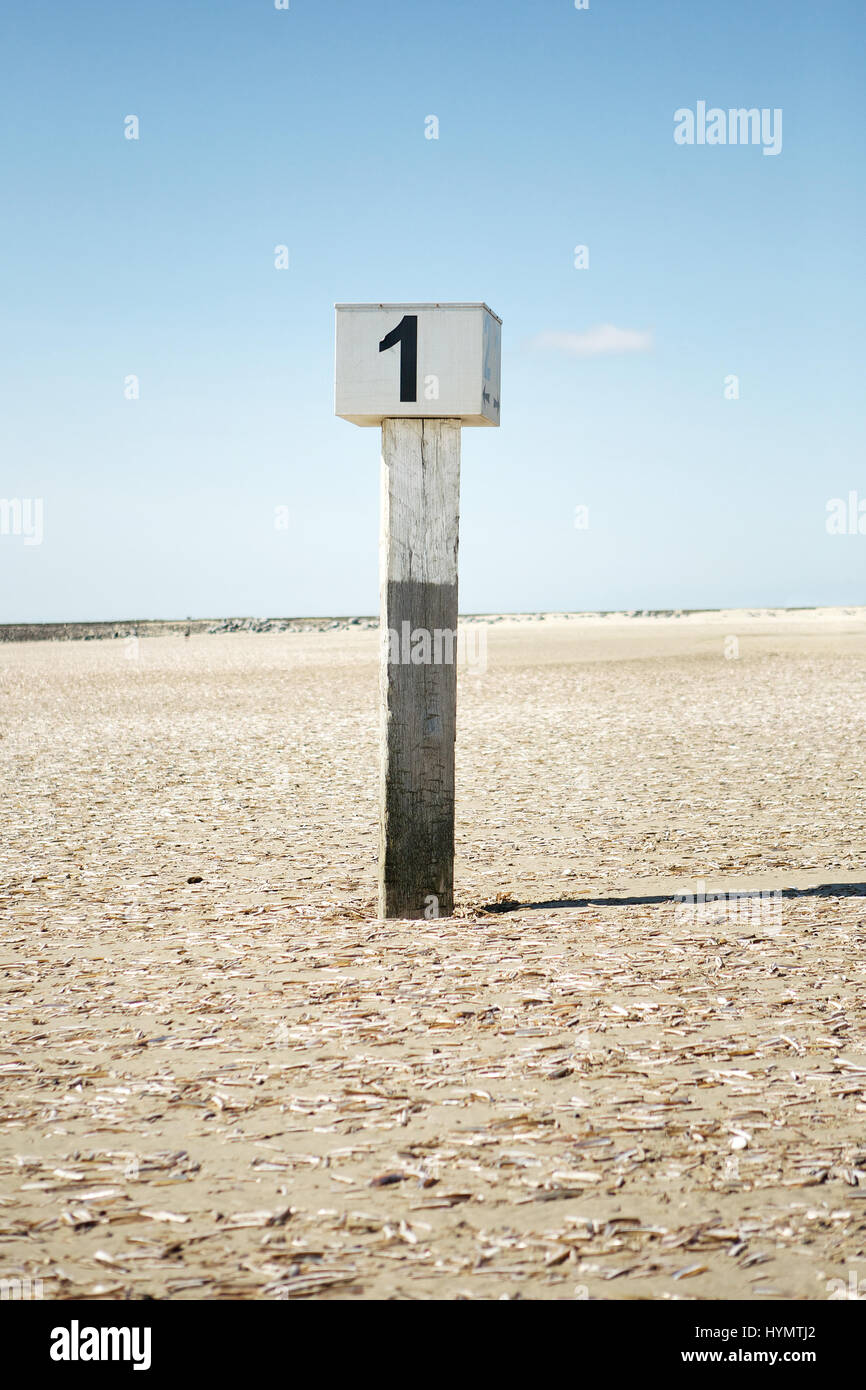 A Single tide pole on sandy beach with number one Stock Photo - Alamy