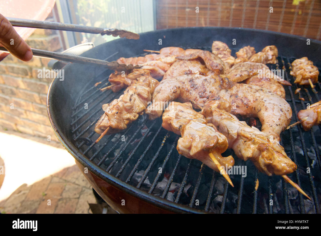 Close up hand with tongs barbecue chicken Stock Photo - Alamy