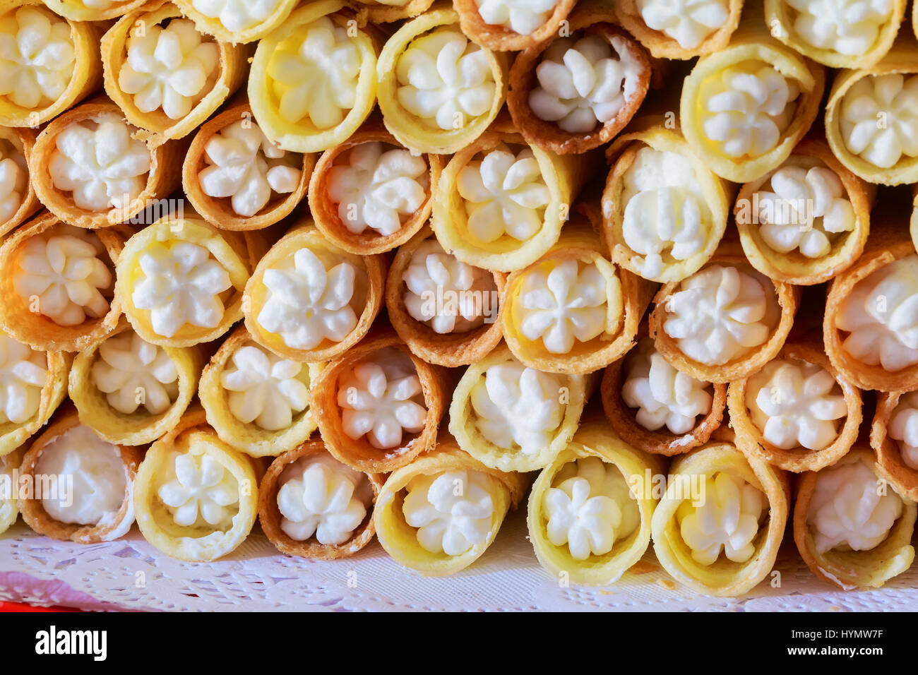Rows of freshly baked sweet buns or bread rolls with sweet filling and ...