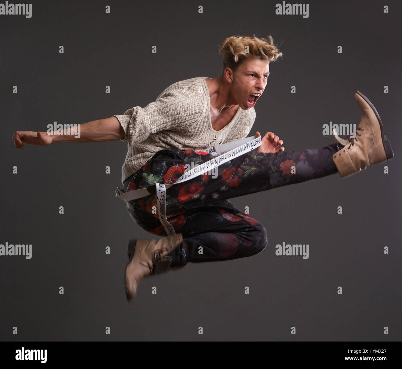 Portrait of a male dancer jumping and shouting on gray background Stock ...