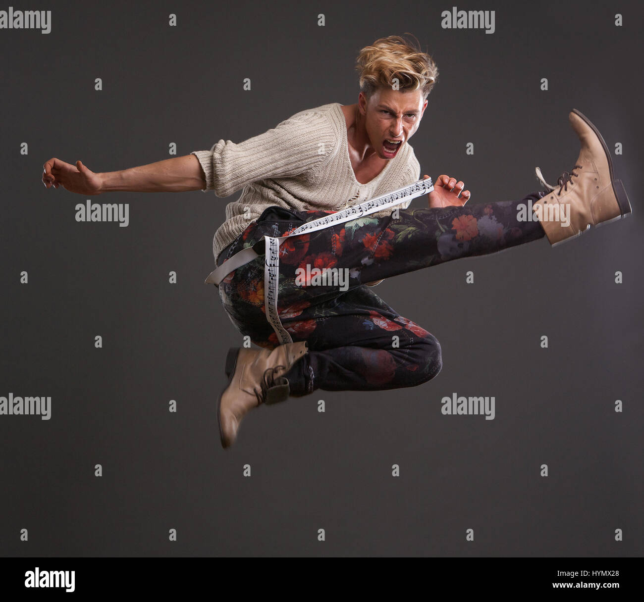 Portrait of a young male dancer jumping on gray background Stock Photo ...