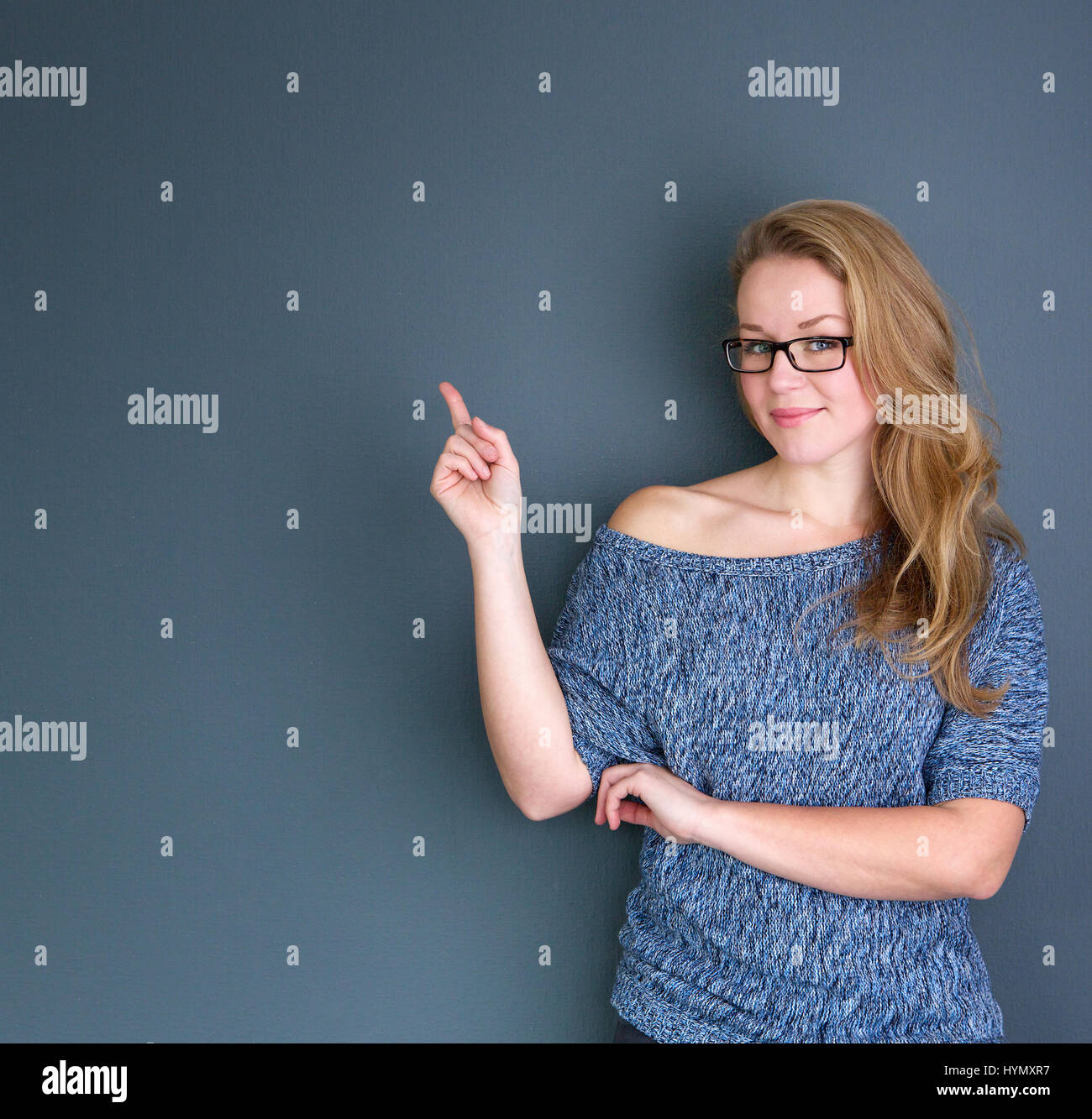 Close up portrait of a young lady pointing finger showing copy space on ...