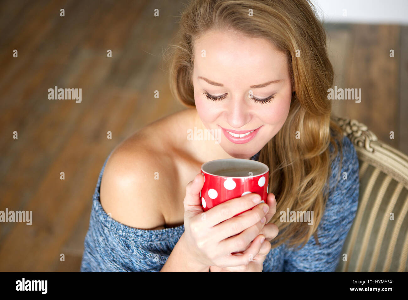 Close up portrait of a happy young woman enjoying a cup of tea at home ...