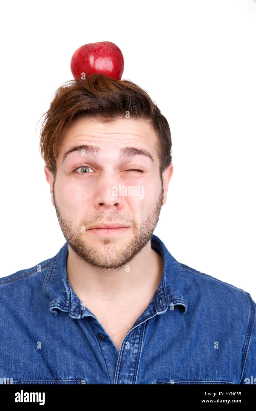 Portrait of a young man balancing red apple on head Stock Photo - Alamy