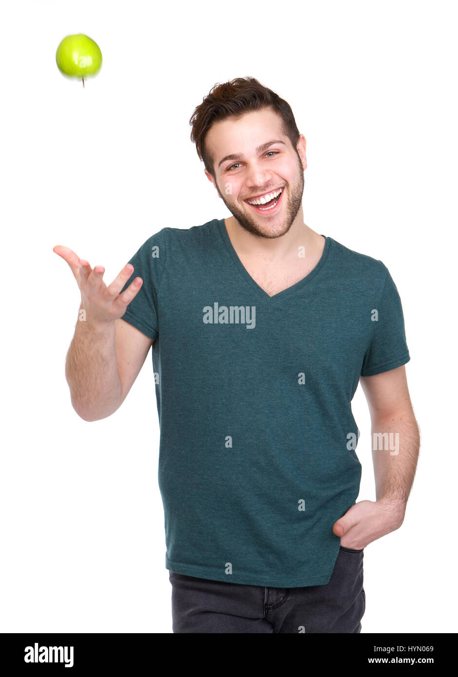 Portrait of a handsome man smiling and throwing apple up isolated on ...
