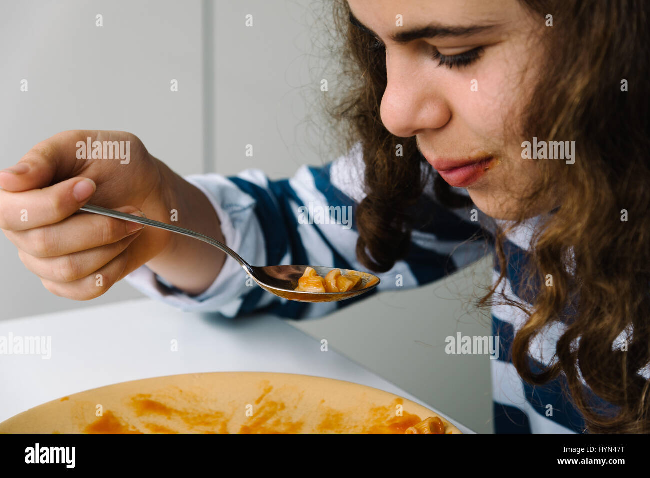 Girl eating pasta with spoon. Close up side view Stock Photo - Alamy