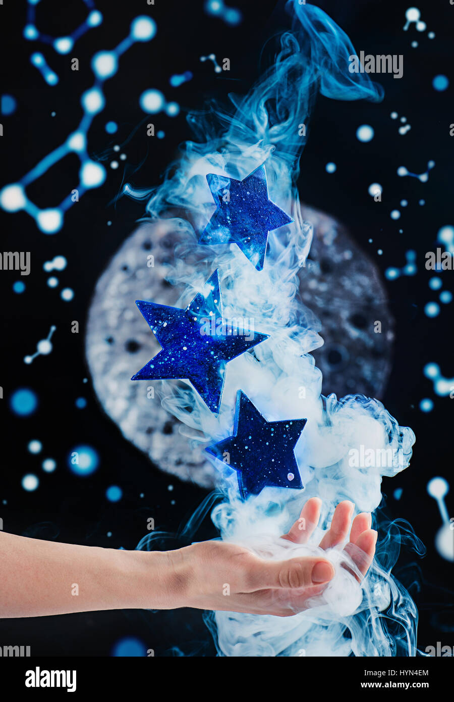 Reaching for stars: a hand with falling stars and smoke Stock Photo - Alamy