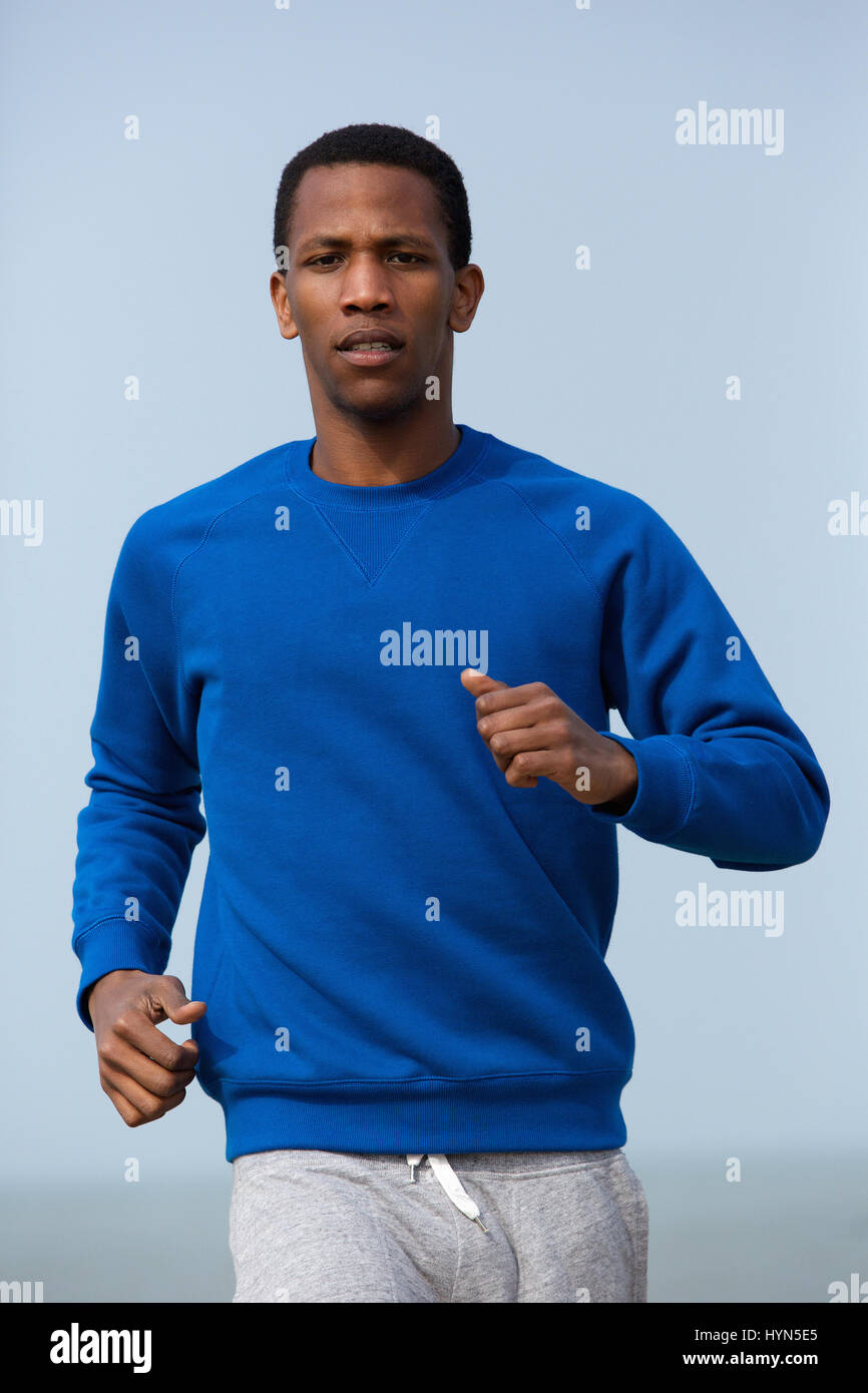 Close up portrait of a young athletic man jogging outdoors Stock Photo ...