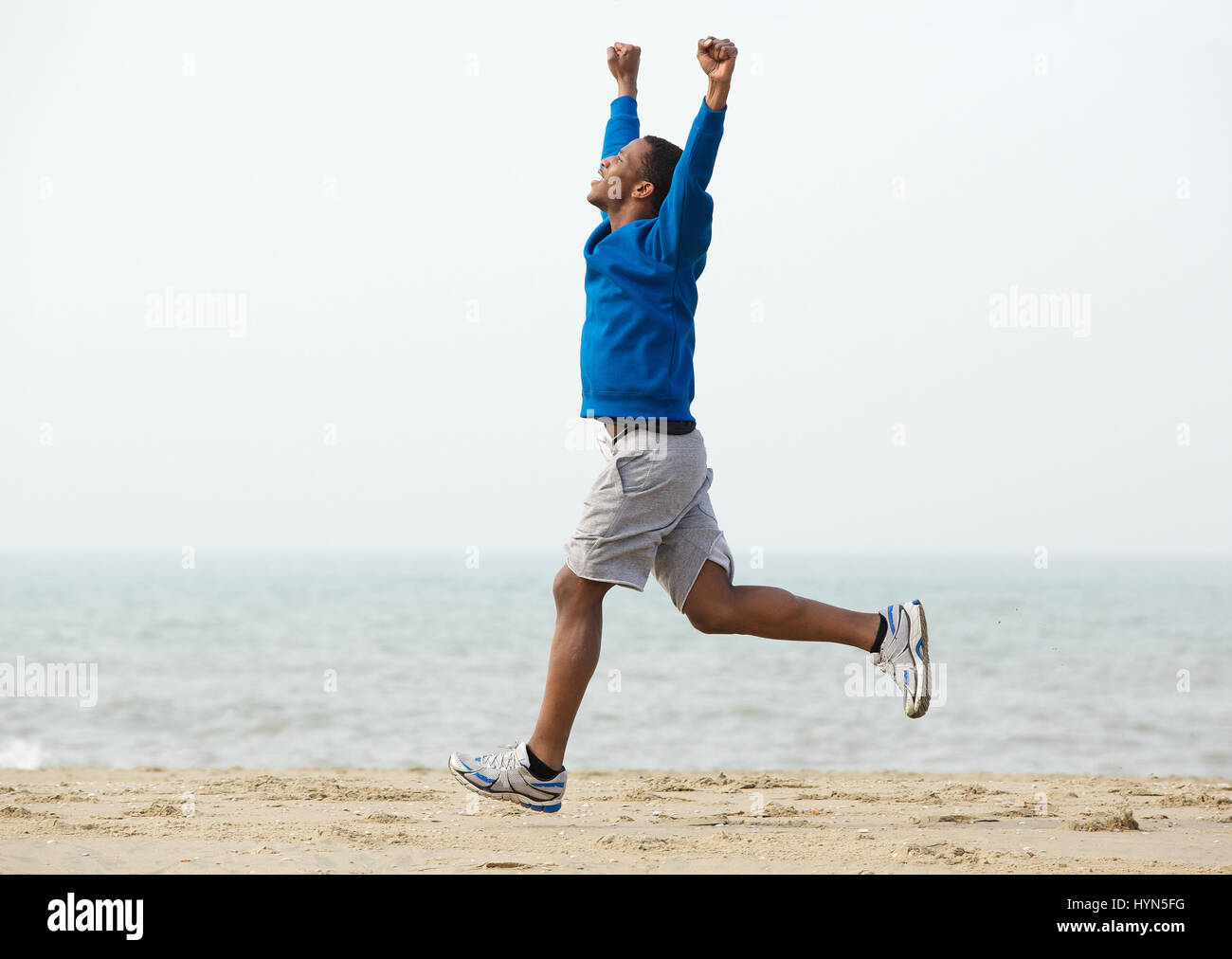 Happy young man running outdoors and celebrating with arms raised Stock ...