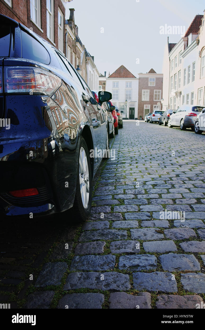 Side parking on the small street in old city Stock Photo - Alamy