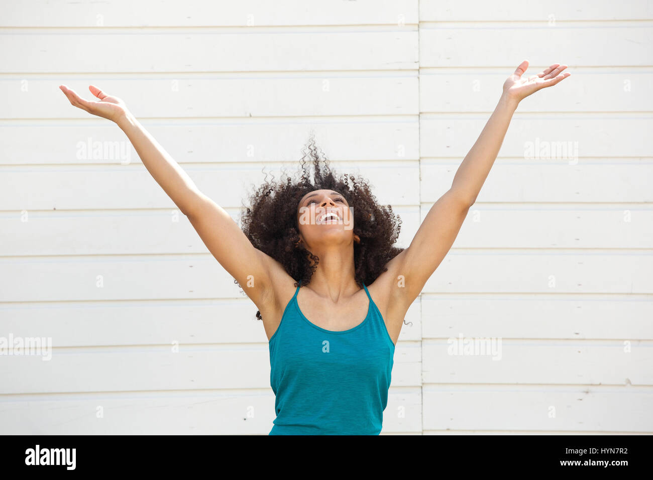 Portrait of a young woman looking up with arms outstretched Stock Photo ...