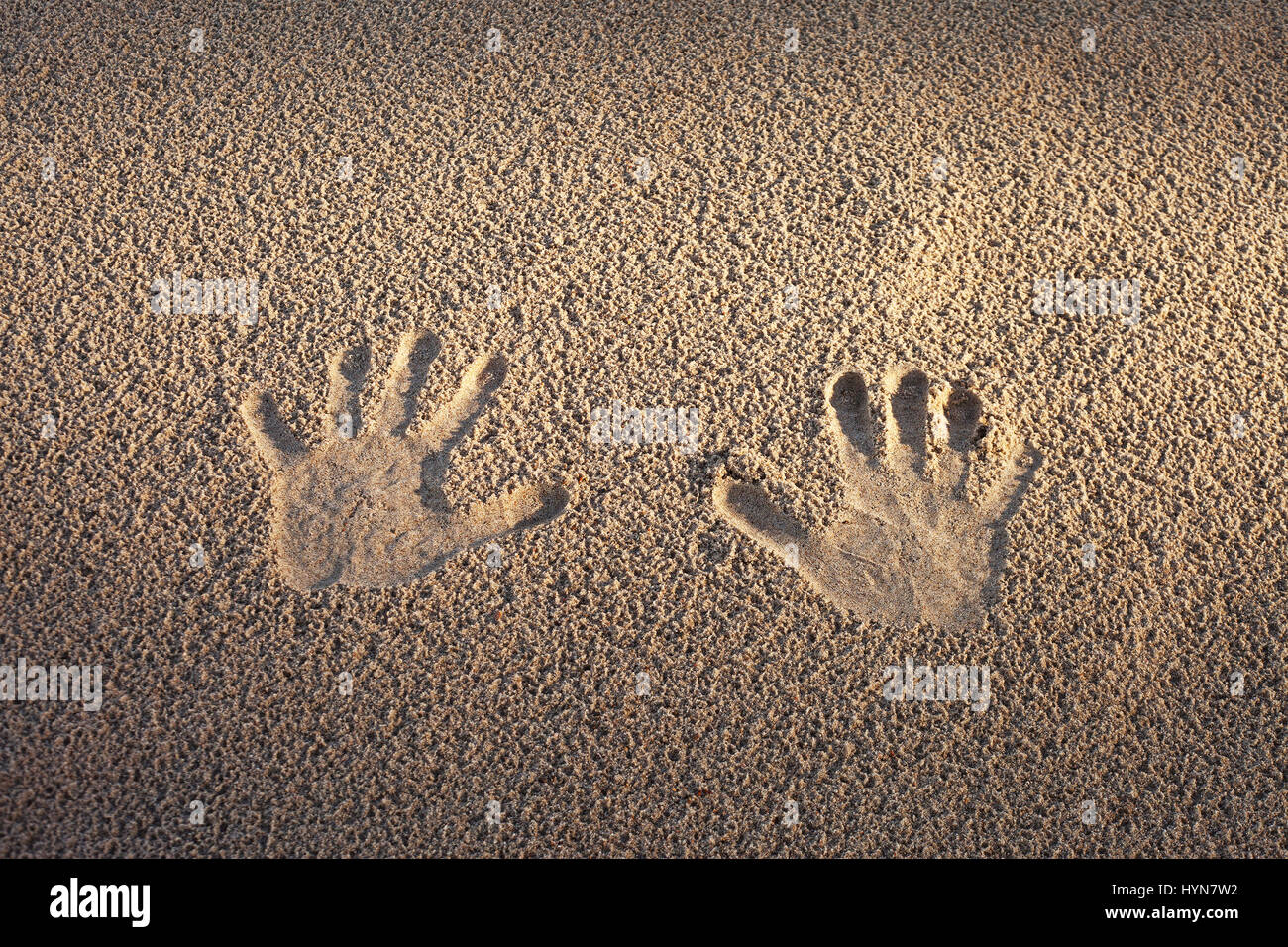 Hand prints in sand Stock Photo - Alamy