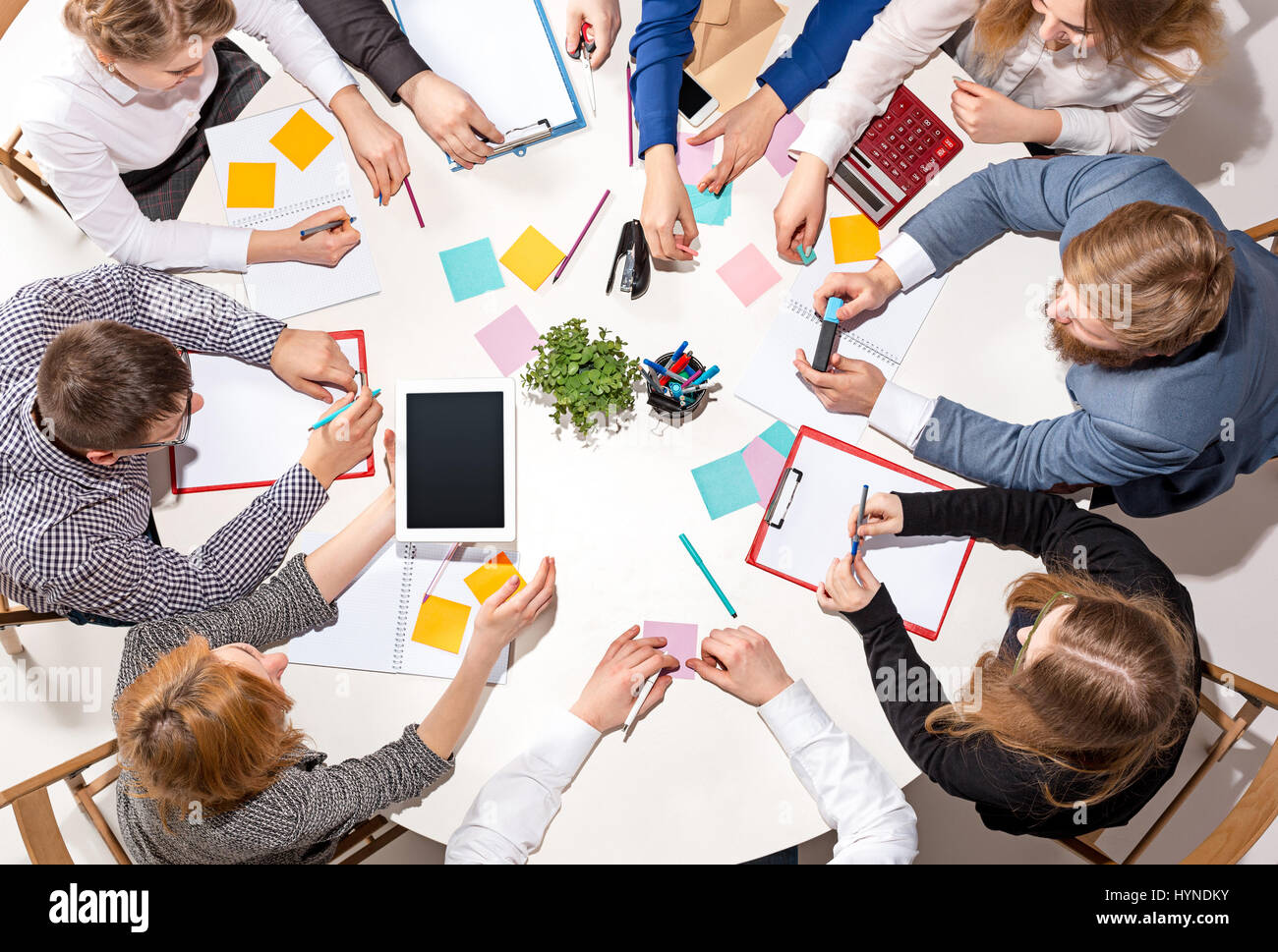 Team sitting behind desk, checking reports, talking. Top View Stock ...