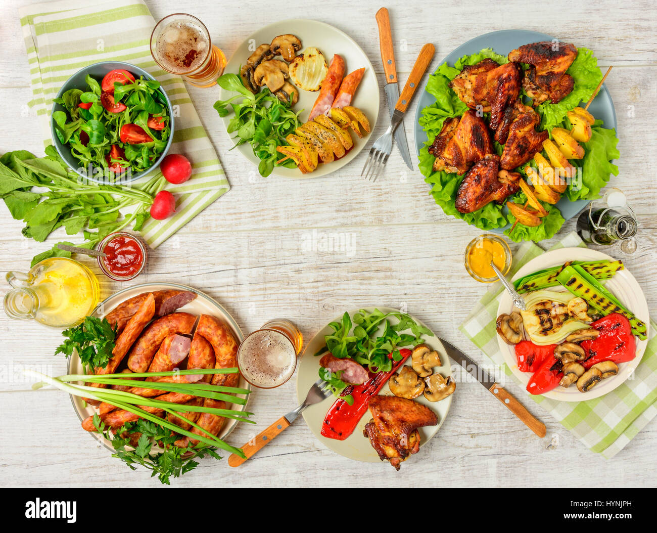 Dinner table with variety food, fried chicken wings, sausages, grilled ...