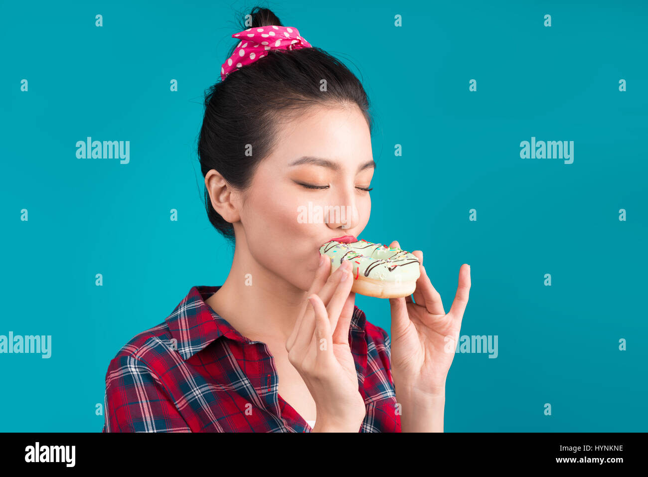 Retro joyful woman enjoy sweets, dessert standing over blue background ...